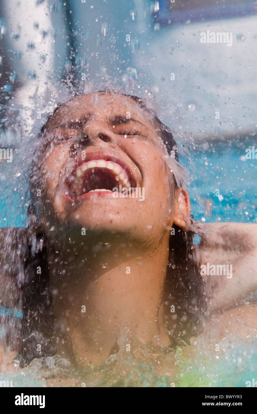 Young woman getting a splash of water in the pool Stock Photo - Alamy