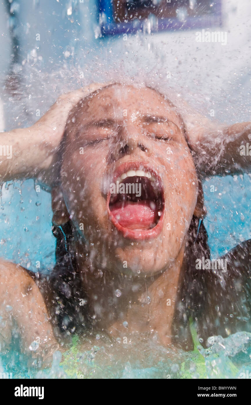 Young woman getting a splash of water in the pool Stock Photo - Alamy