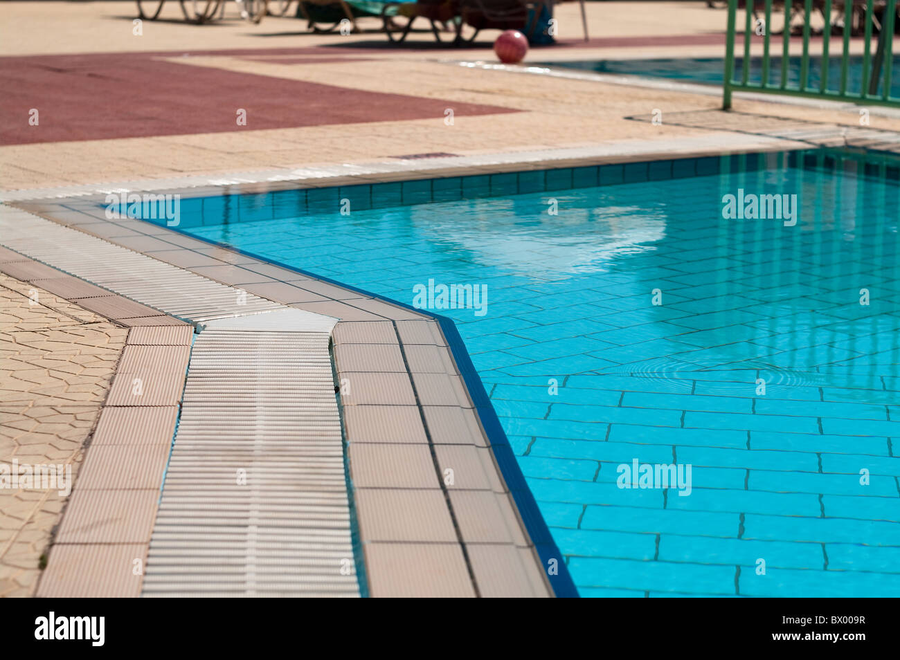 Edge of swimming pool with blue water and poolside around Stock Photo ...