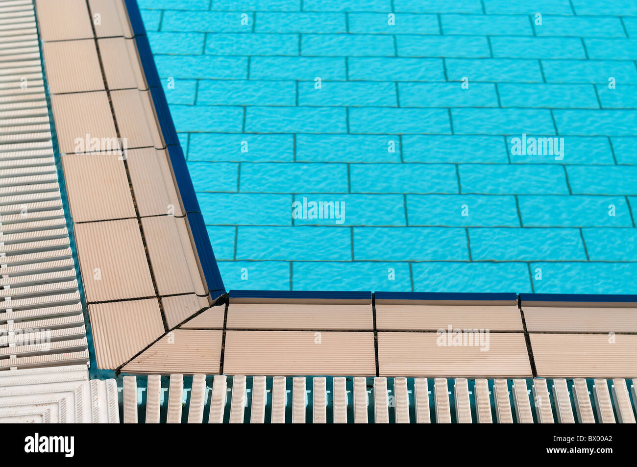 Edge of swimming pool with blue water and poolside around Stock Photo ...