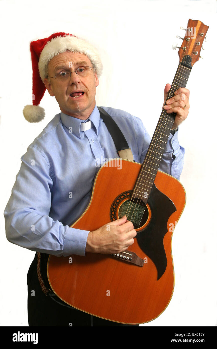 November 2005 - A mature Christmas vicar playing his guitar while ...