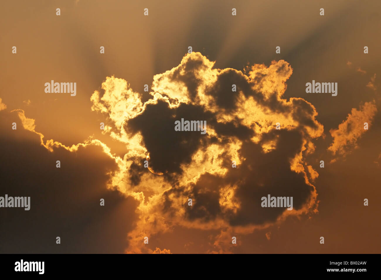 Evening sun hiding behind clouds Stock Photo - Alamy