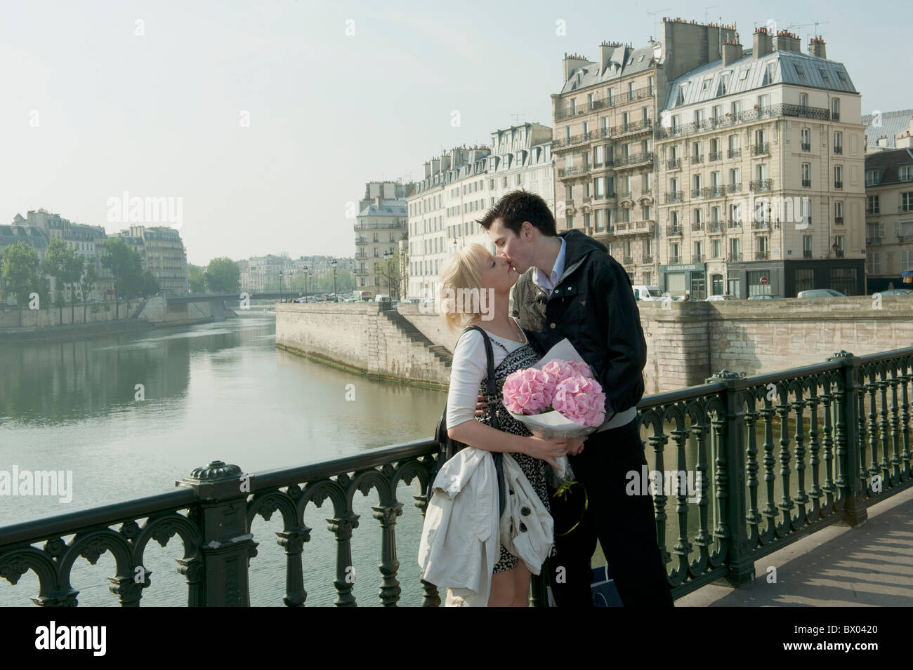 Caucasian couple kissing on bridge Stock Photo - Alamy