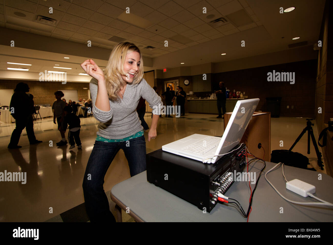 A woman dances to music playing from a laptop at a party Stock Photo ...