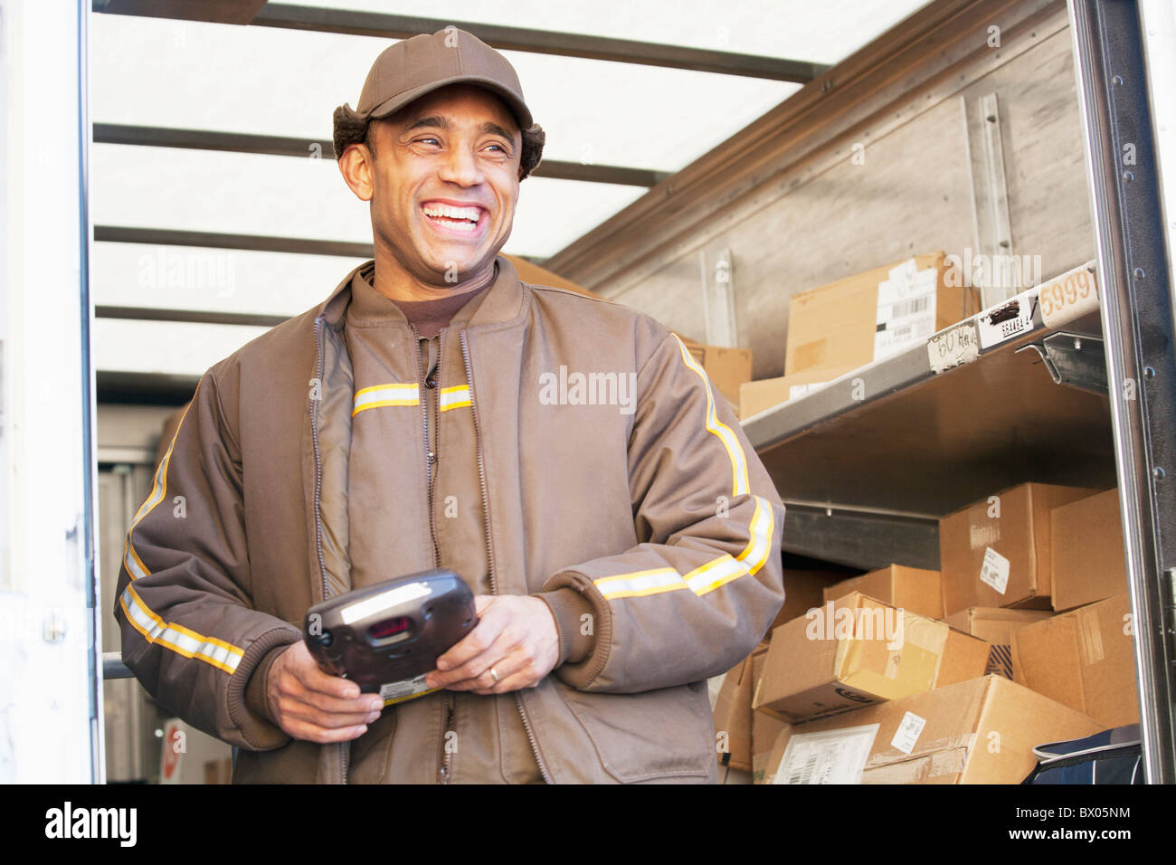 Smiling Hispanic delivery man standing in back of truck Stock Photo - Alamy
