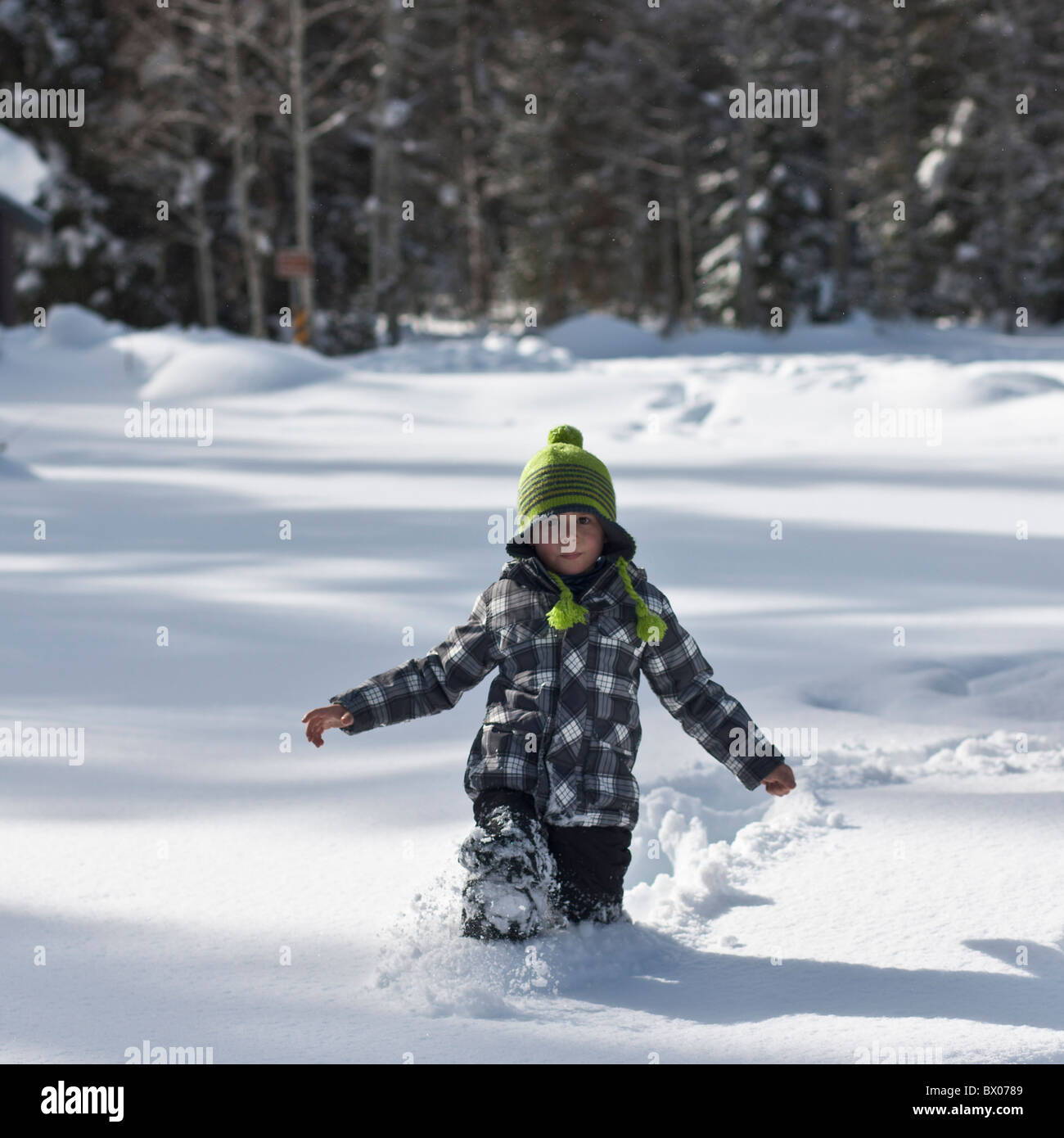 Little boy enjoying winter while running in snowy meadow Stock Photo ...