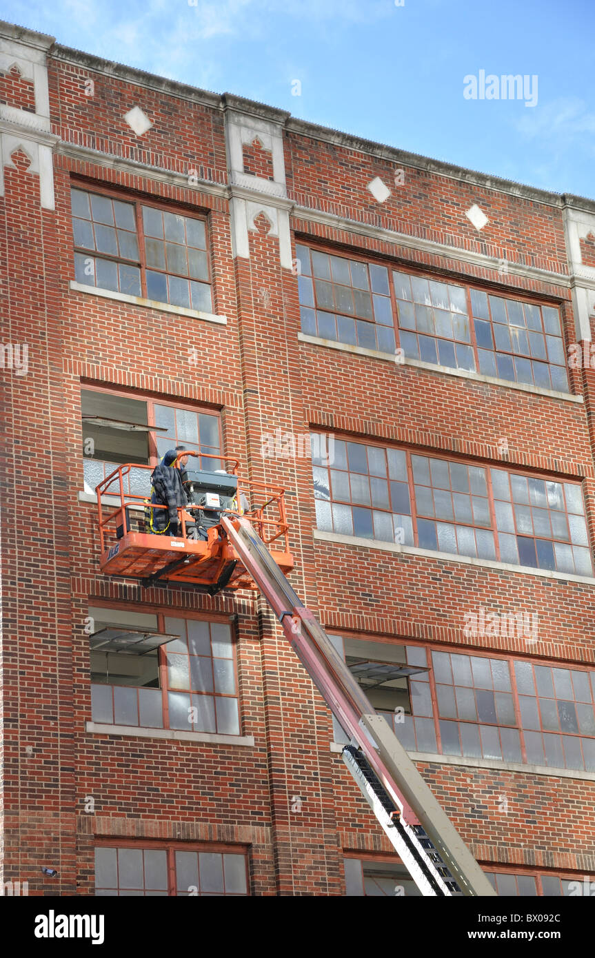 Man on hydraulic lift washing windows Stock Photo - Alamy