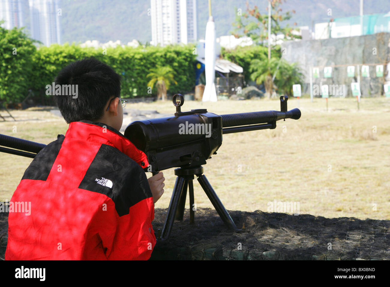 Chinese boy practice on a fake machine gun in the shooting range, Citic ...
