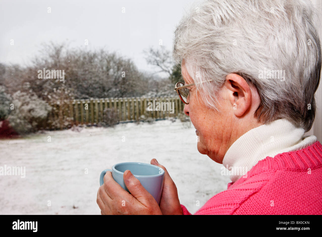 Elderly senior woman OAP lady living alone holding a hot drink and ...