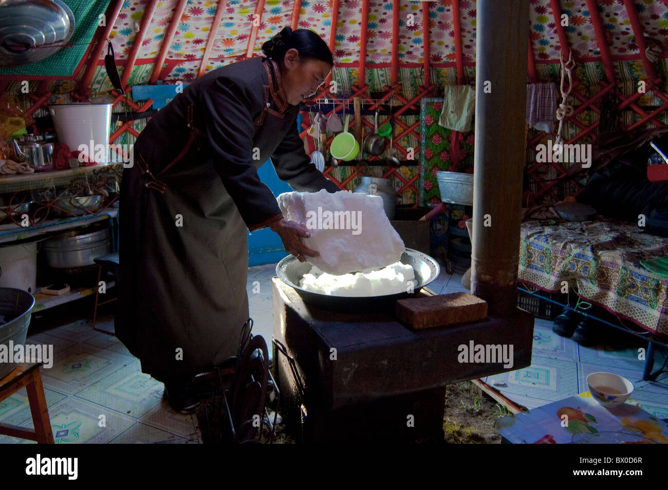 Barag Mongolian woman thawing ice to to boil water, Old Barag Banner ...