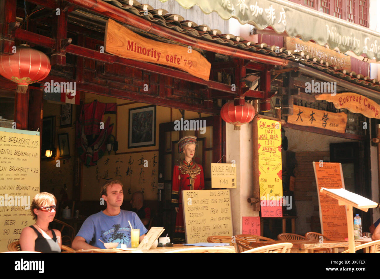 Caucasian couple resting beside Minority Cafe 7, West Street, Yangshuo ...