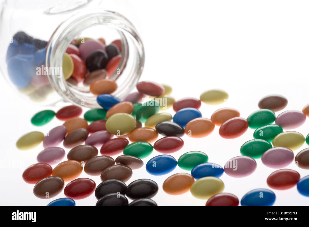 lots of colorful candies spread on white background Stock Photo - Alamy