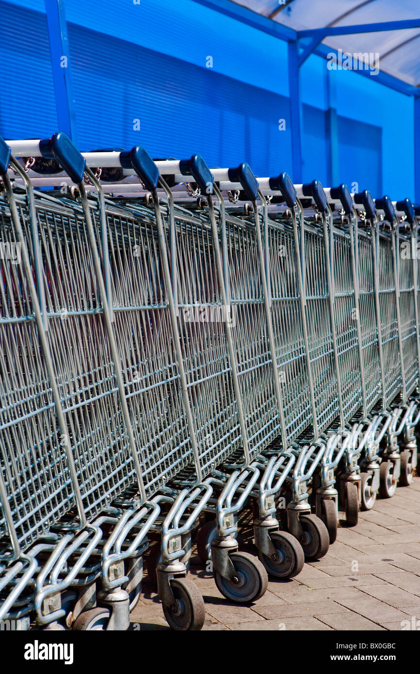 a line of empty supermarket shopping carts against blue wall Stock ...