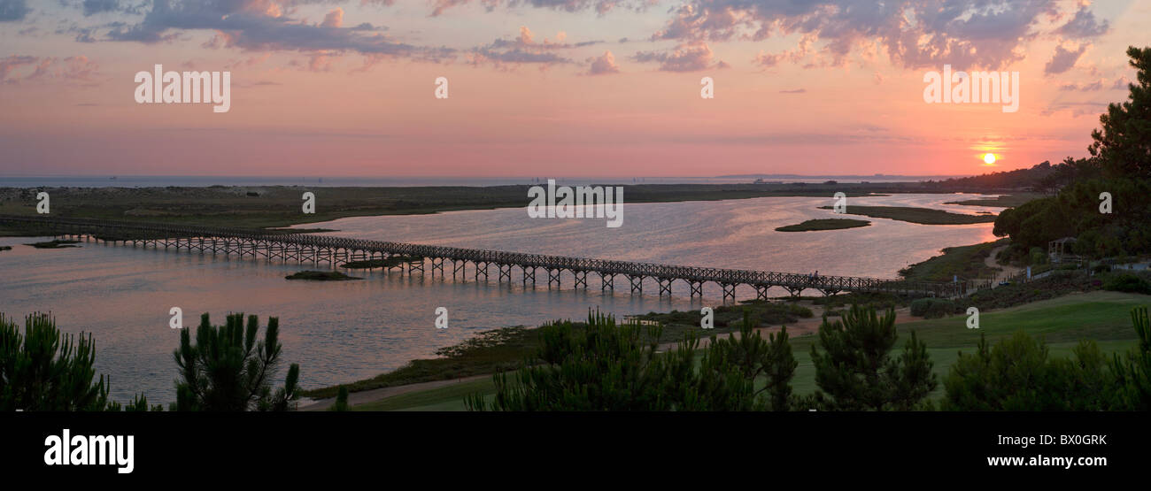Portugal, the Algarve, sunset over the lagoon and the wooden bridge to ...