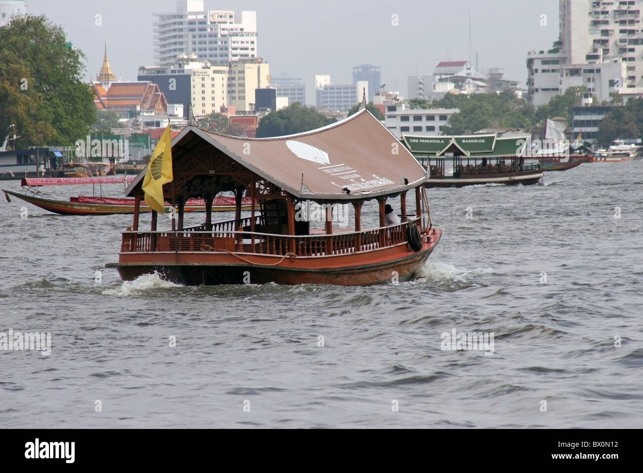 A ferry boat is crossing the Chao Phraya river in Bangkok, Thailand ...