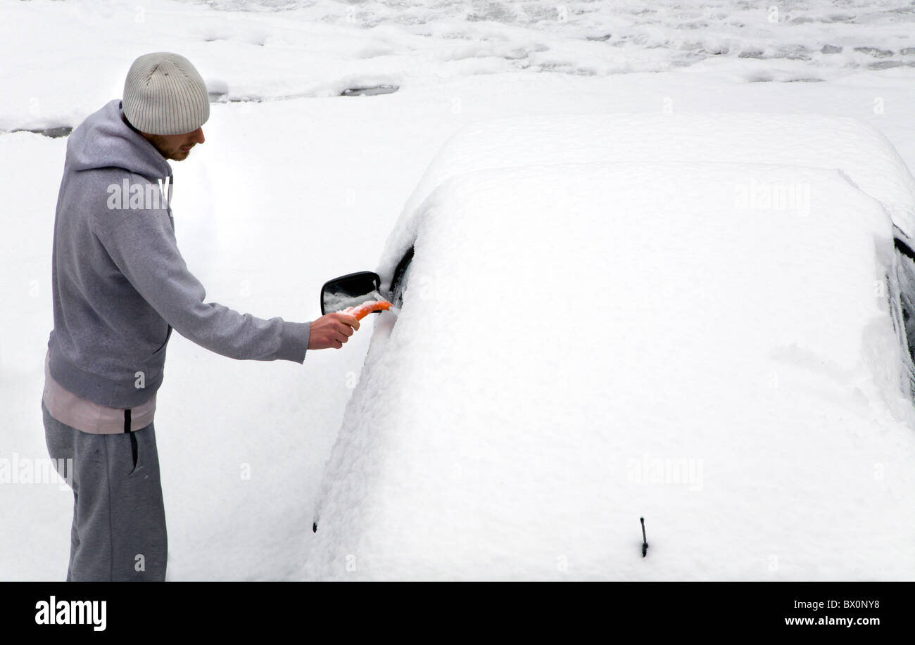 A YOUNG MAN CLEARING SNOW AND ICE OFF HIS CAR Stock Photo - Alamy