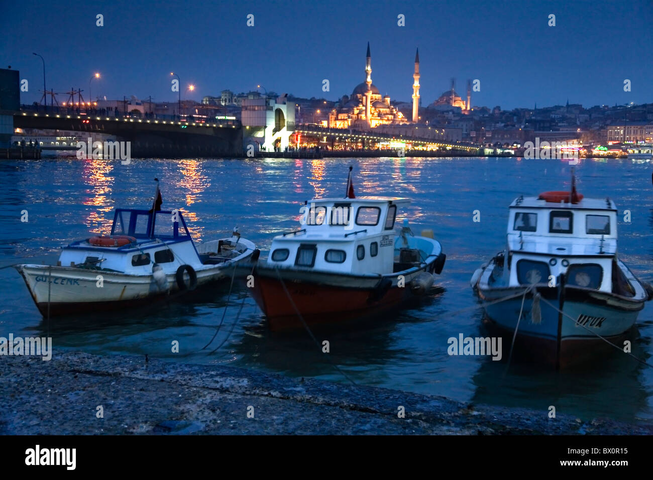 The Yeni Mosque, Galata Bridge and boats at sunset. Golden Horn ...
