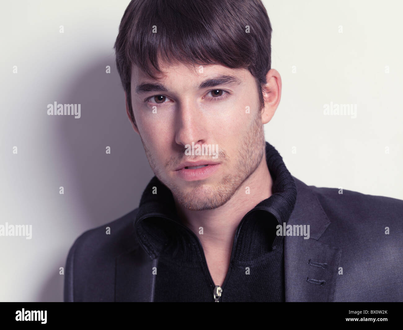 Fashion portrait of a young man wearing a black blazer and a sweater ...