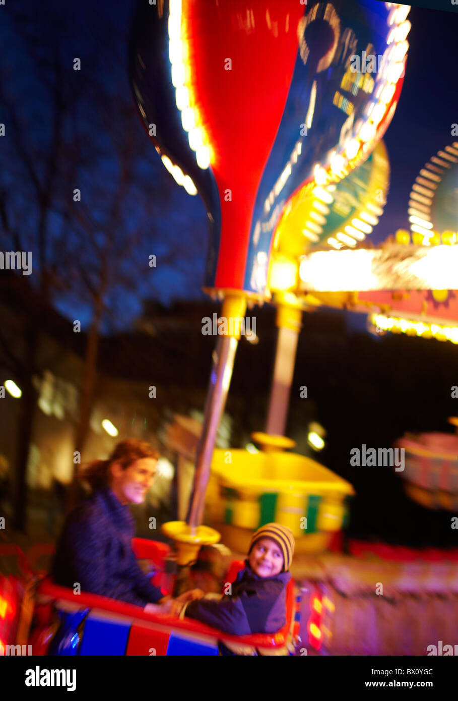 kids on fairground ride at dusk Stock Photo - Alamy