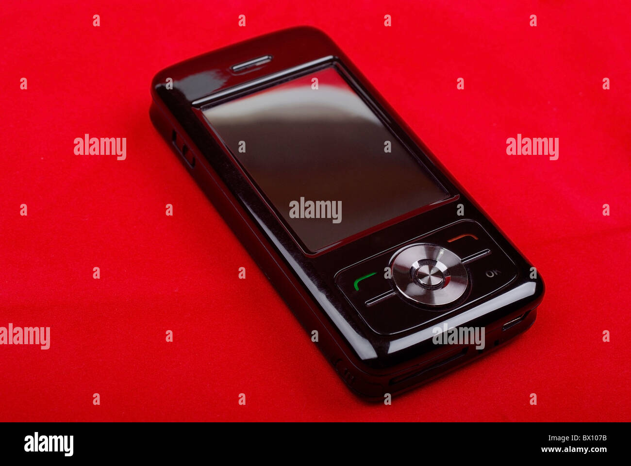 Shiny black PDA phone isolated on red background Stock Photo - Alamy