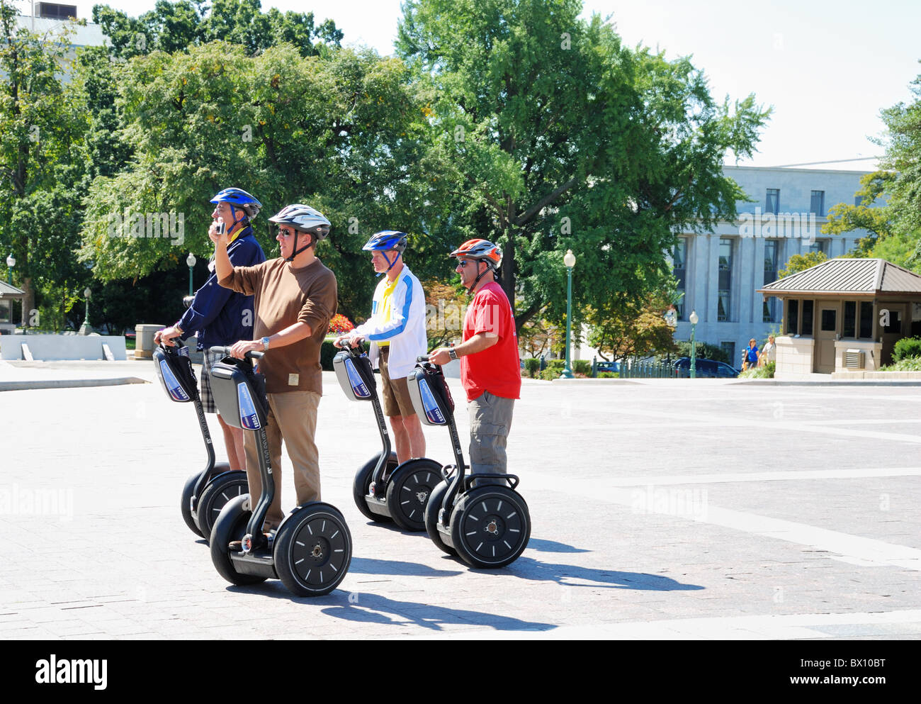 Four tourists on Segway transport vehicles in Washington DC. One rider ...