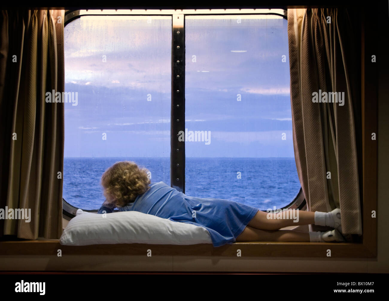 Rainy day at sea, Child looking out of cruise ship window Stock Photo ...