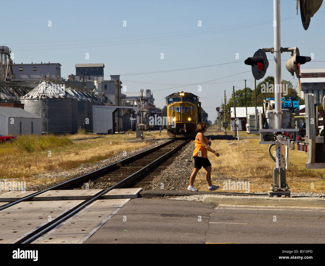 pedestrian crossing rail tracks just before train Stock Photo - Alamy