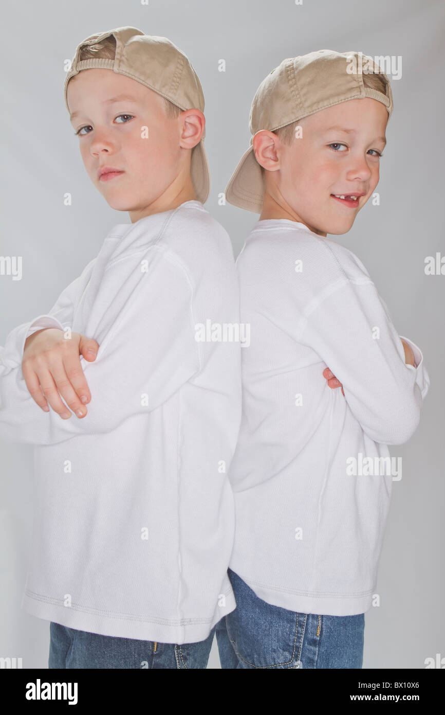 6 years old identical twins wearing a baseball hats smiling Stock Photo ...