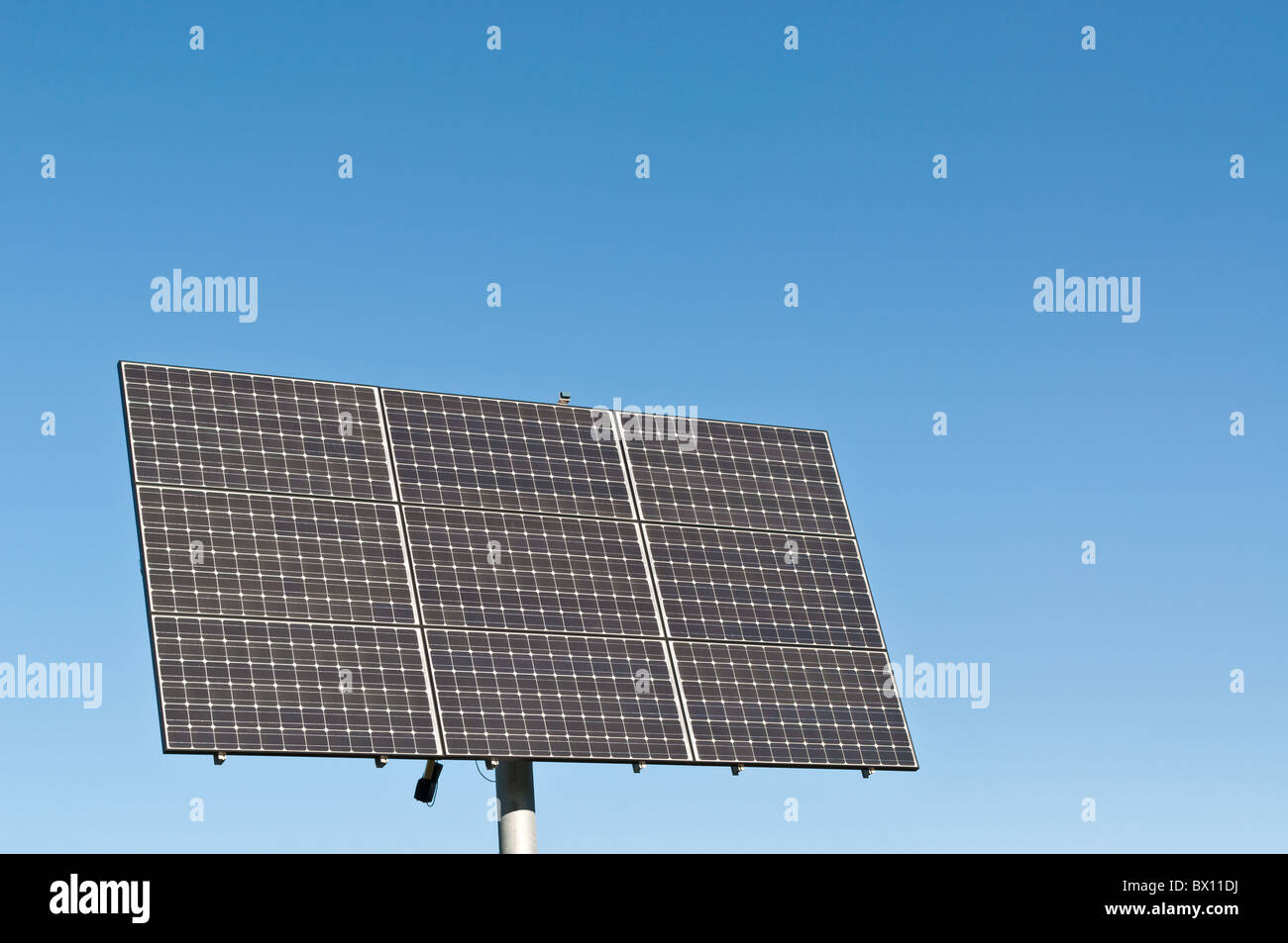 A photovoltaic solar panel array in a park with a deep blue sky in the ...