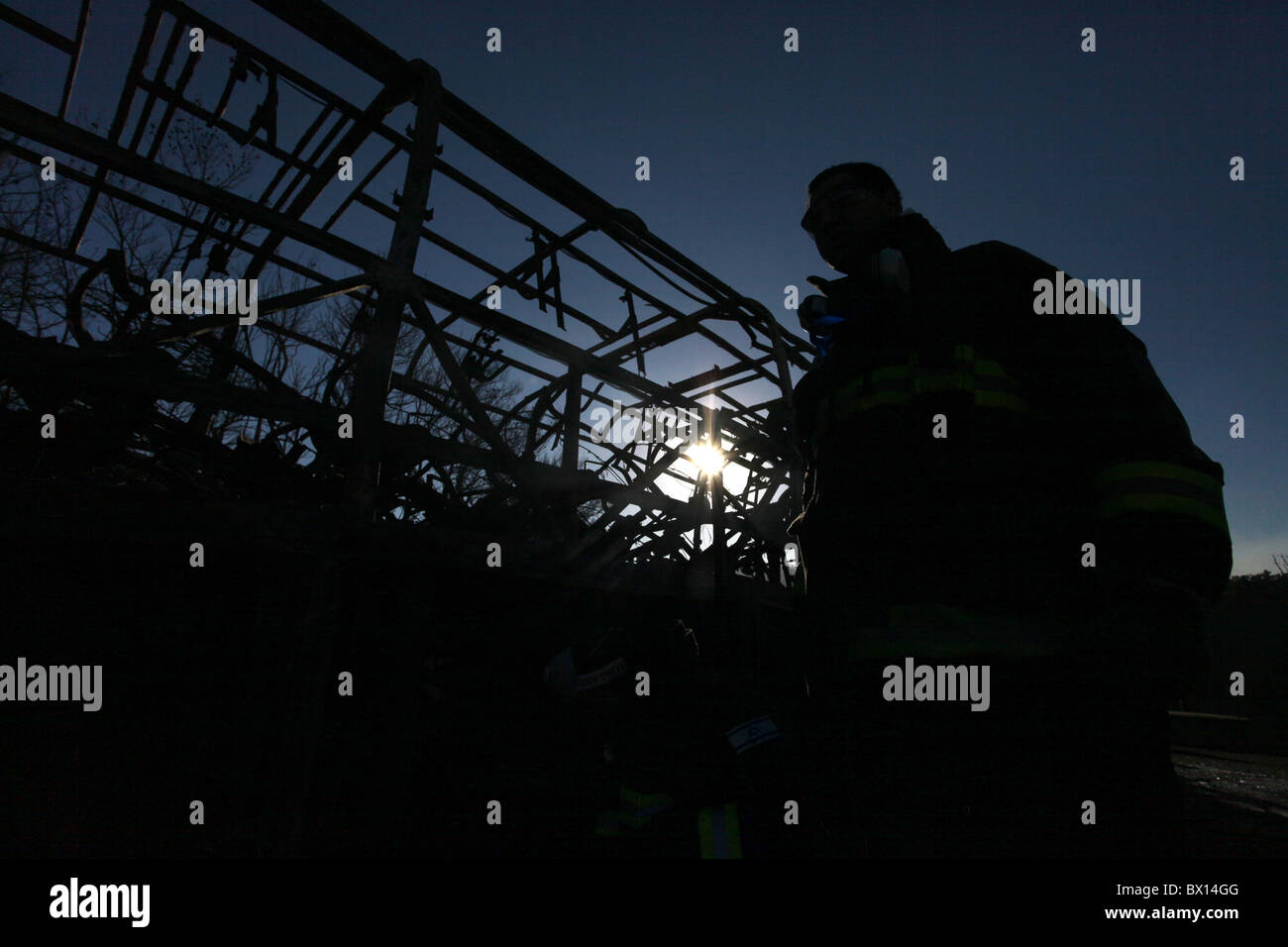 Fireman inspecting the remnant of a bus that was engulfed during a ...