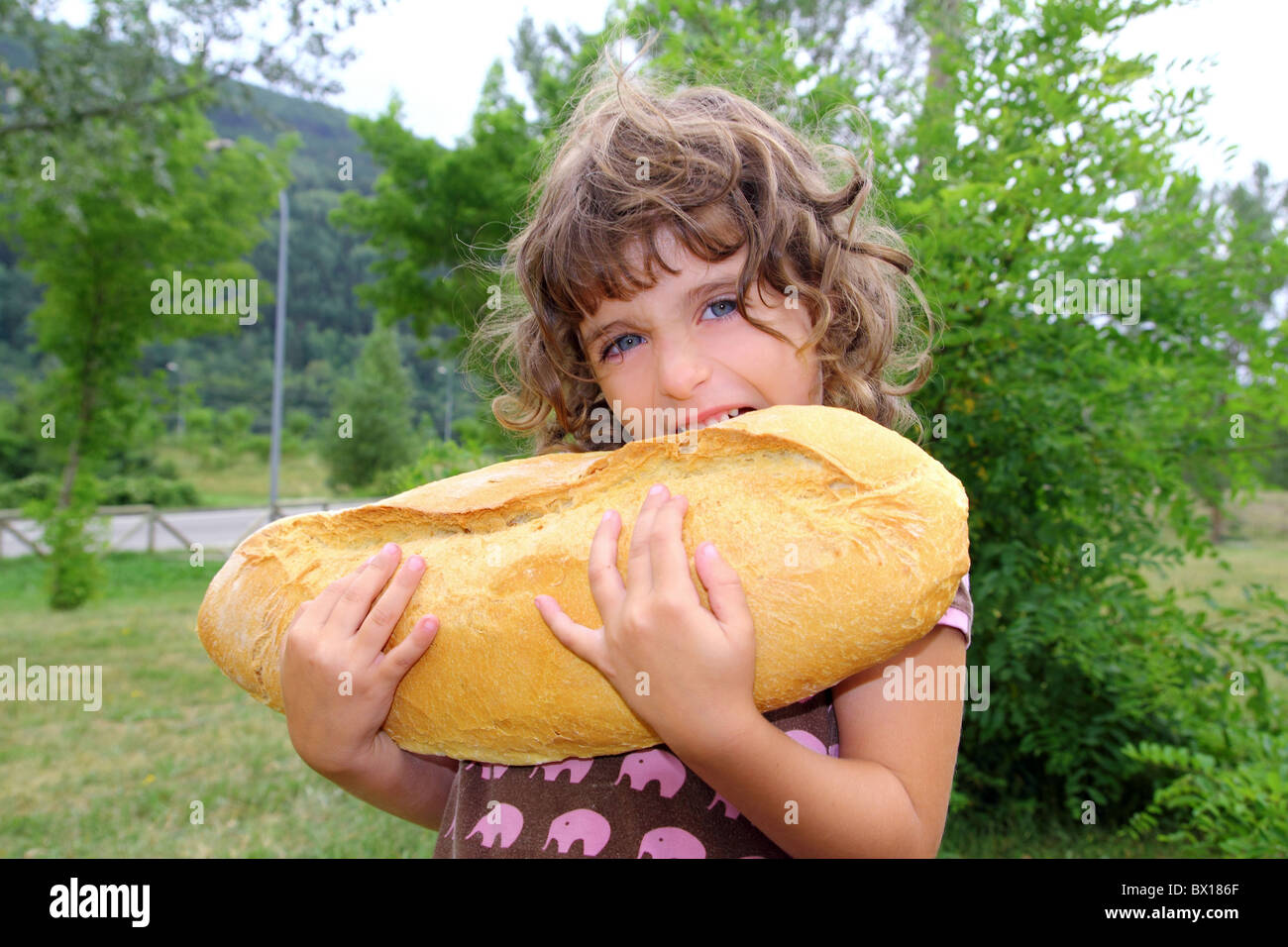 girl eating big bread humor size hungry child funny gesture Stock Photo ...
