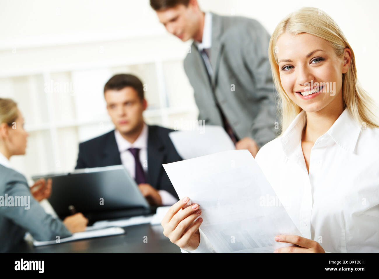 Portrait of pretty young agent with paper on the background of ...