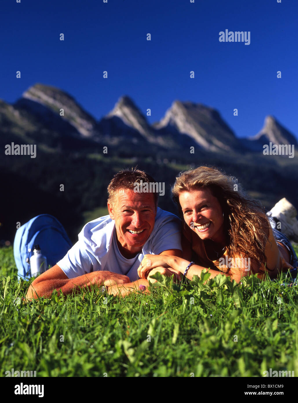 Couple portrait recumbent lie lying couches nature excursion laughing ...