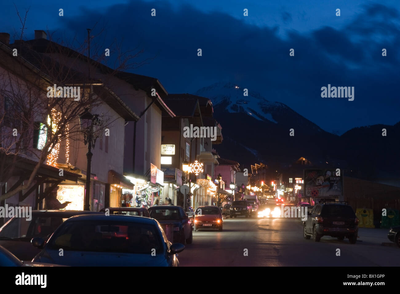 Bansko, traffic street at night, well-known ski resort, Todorka peak at ...