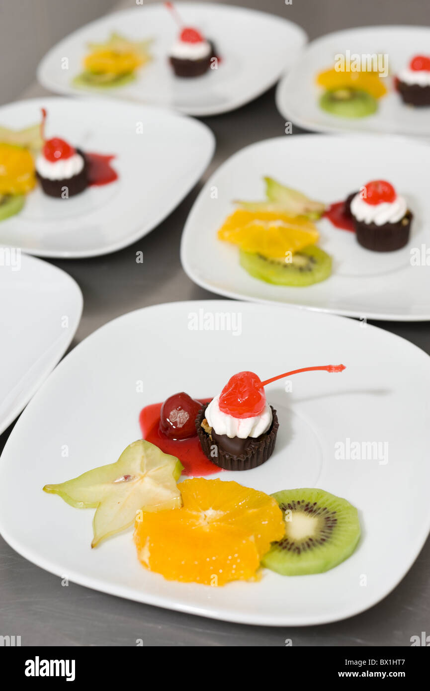 dessert on plates in restaurant kitchen ready for serving up Stock ...