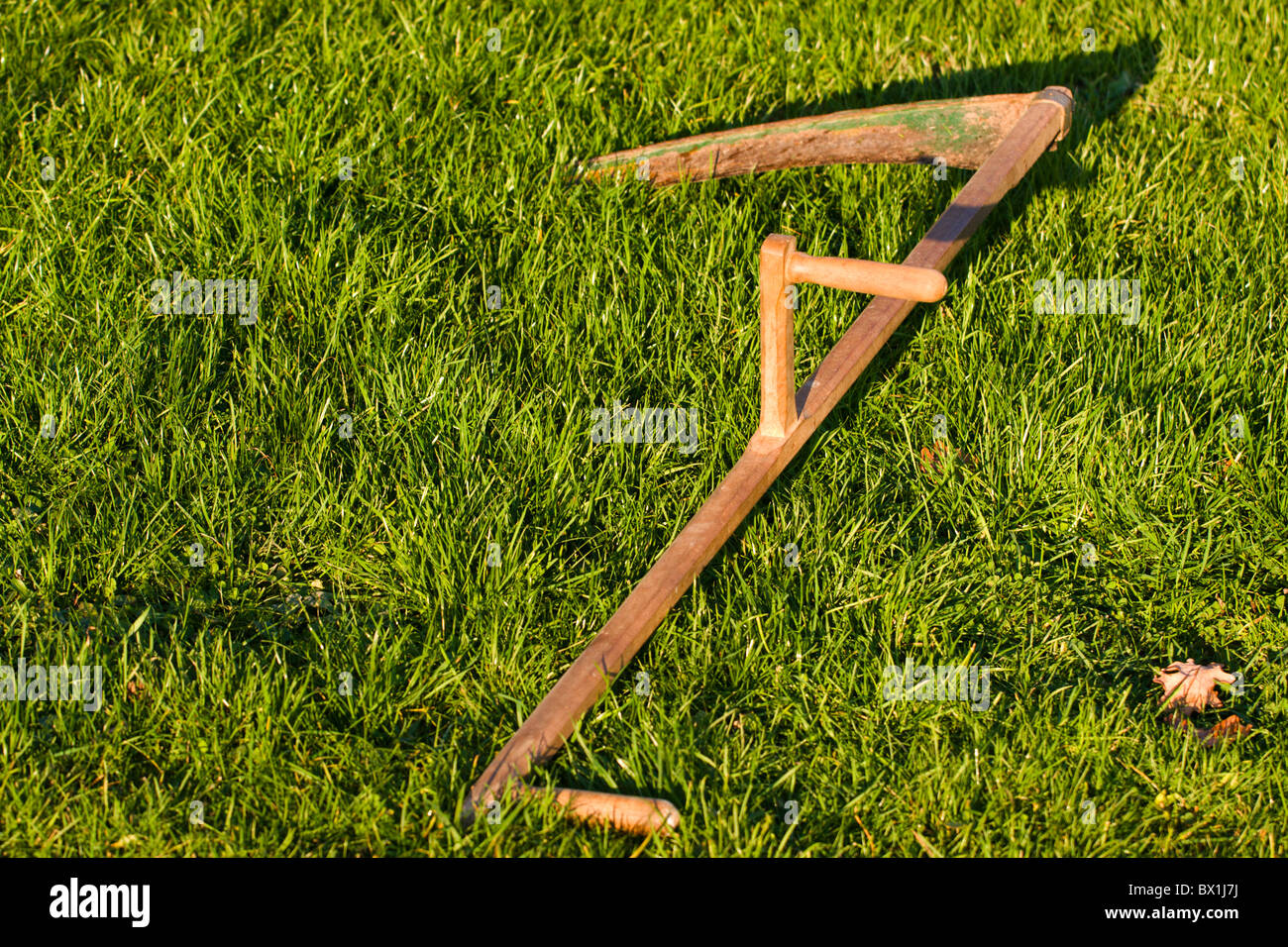 Sharp scythe in the green grass Stock Photo - Alamy