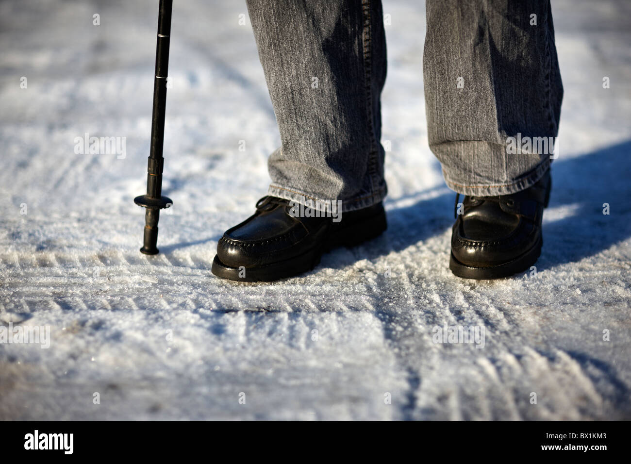 Older person walking on an icy pavement with stick Stock Photo - Alamy