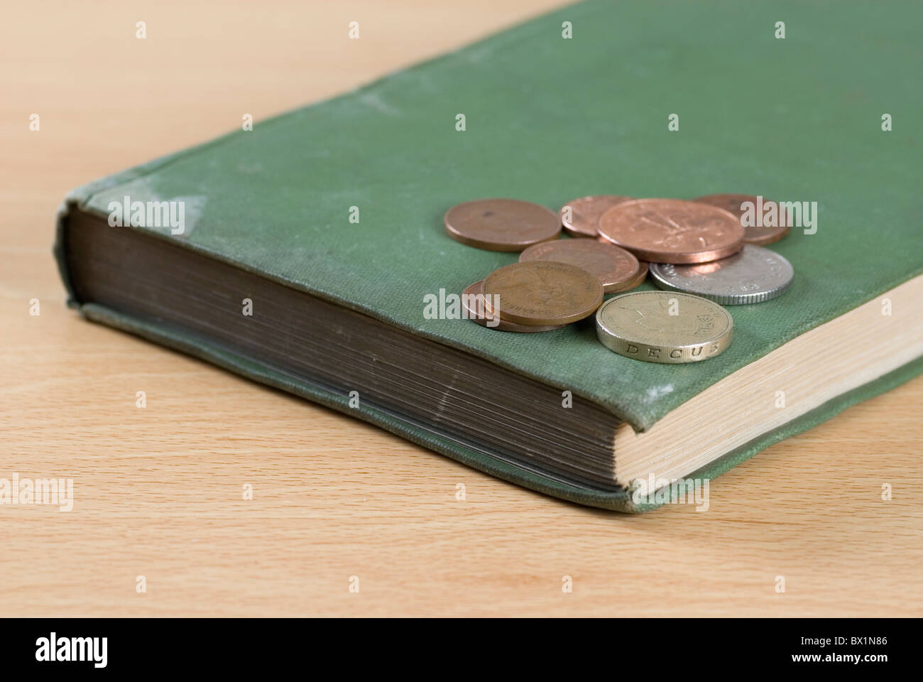 British coins over an old book Stock Photo - Alamy