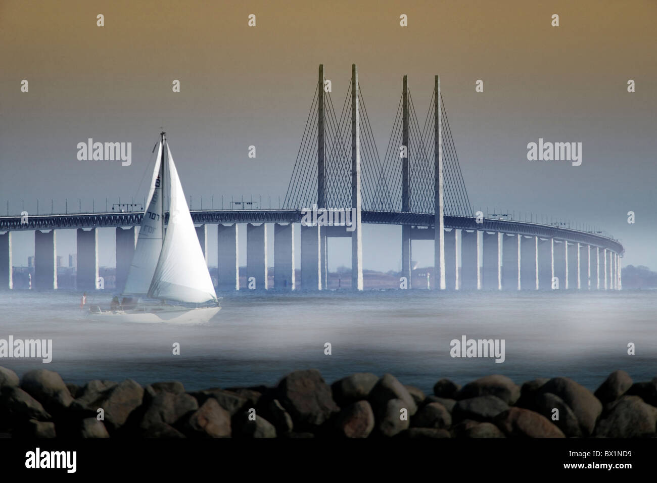 Sailing boat in fog in front of the bridge between Denmark and Sweden ...