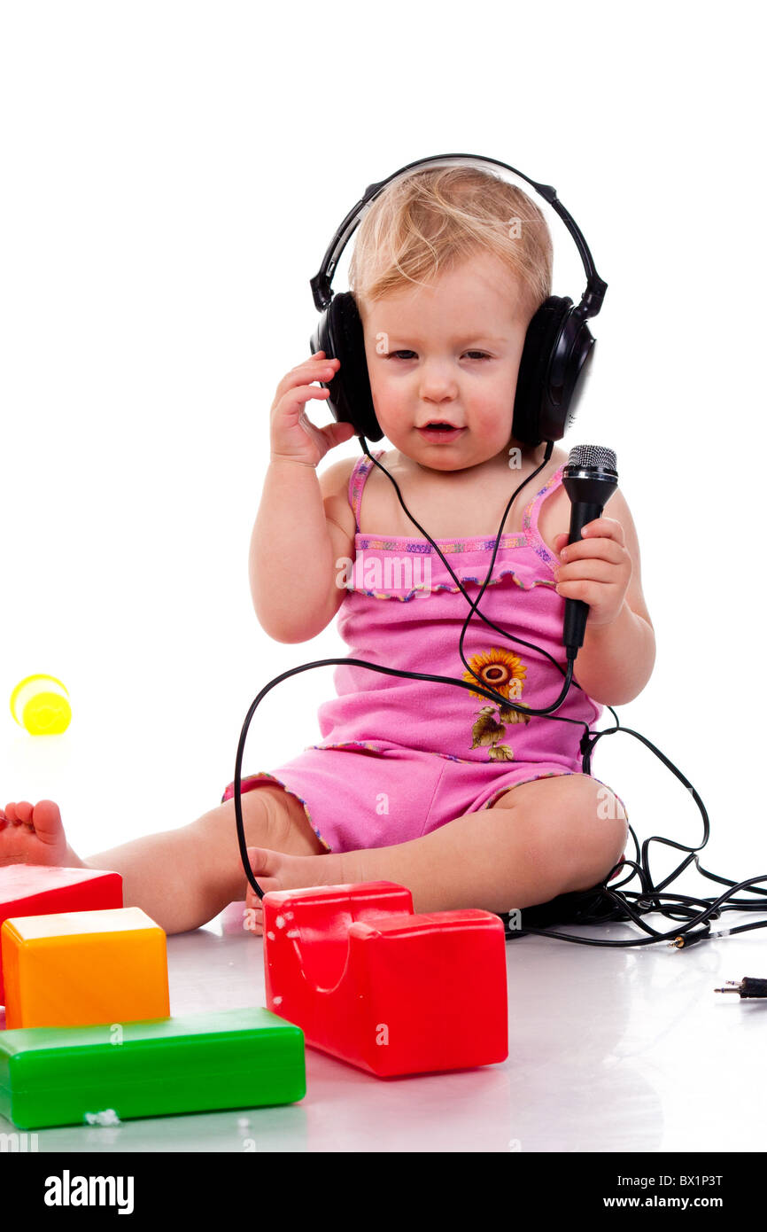 Baby with headphones and microphone, isolated on a white background ...
