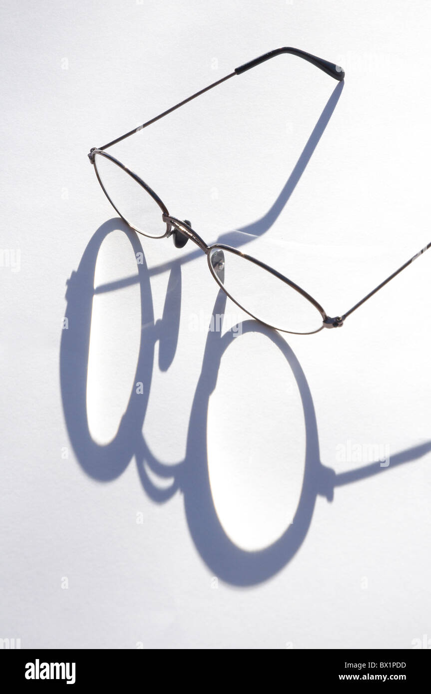 Black framed reading glasses casting shadow Stock Photo - Alamy
