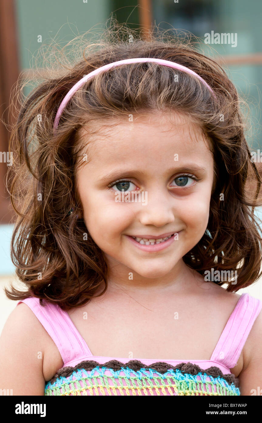 Pretty little girl standing outdoors smiling Stock Photo - Alamy
