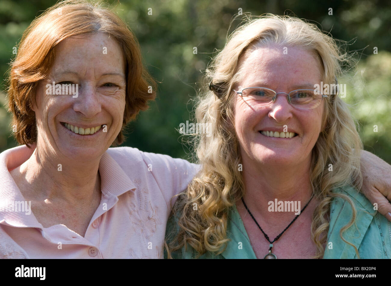 Portrait of two women with arms around each other Stock Photo - Alamy