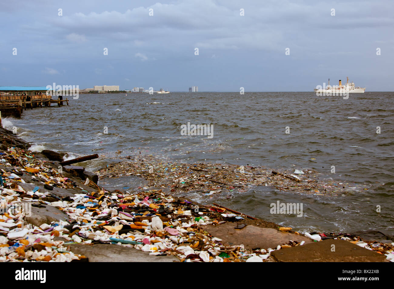 Refuse is washed up on the seawall and floats in Manila Bay Stock Photo ...