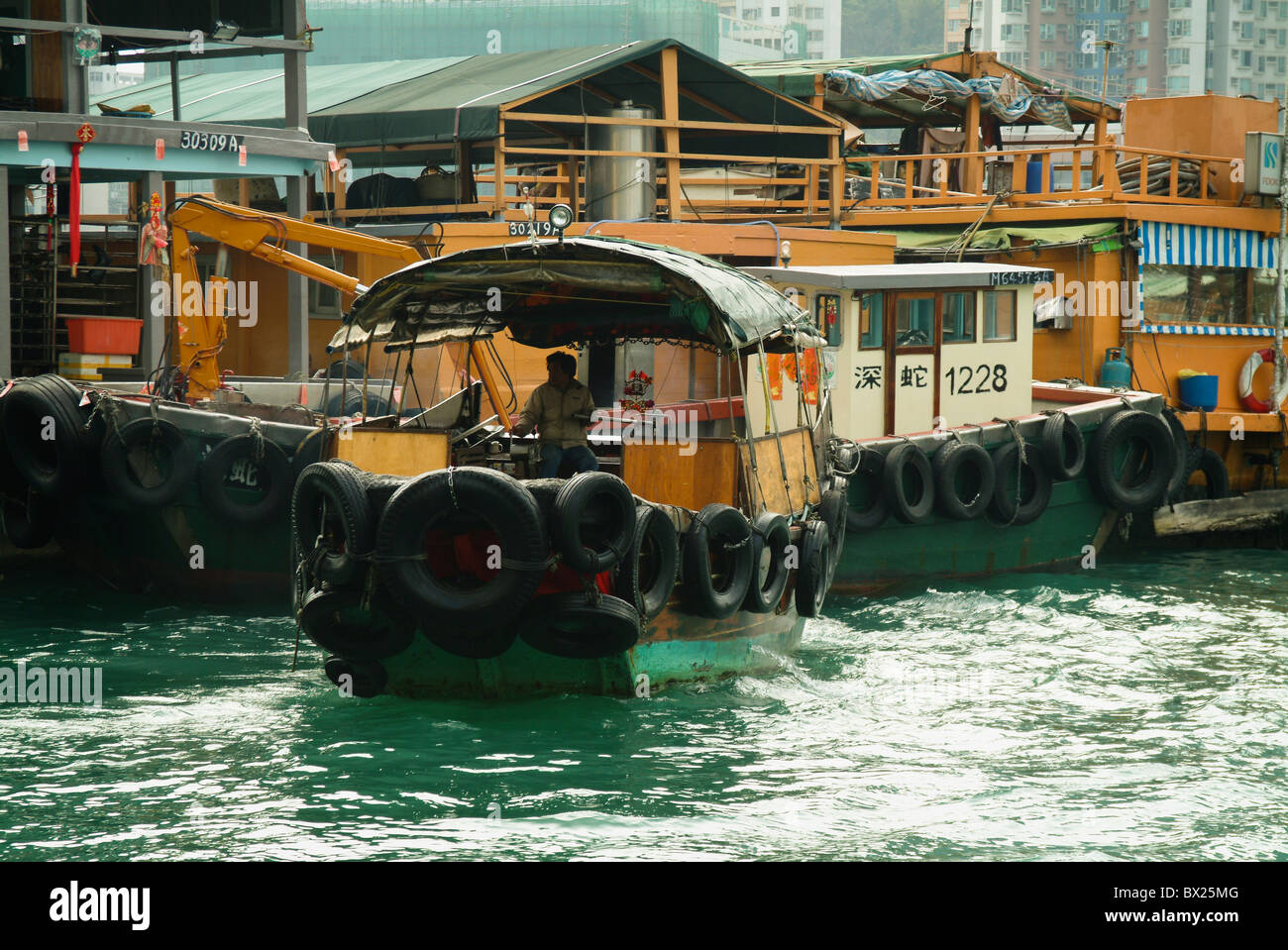 A traditional sampan boat cruises through the protected waters of ...