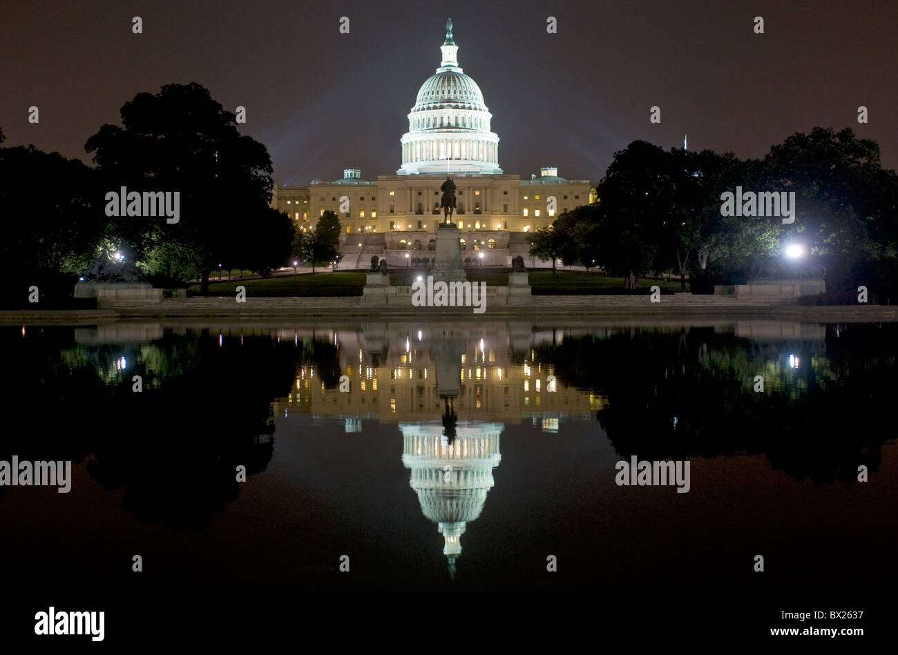 A night time view of the U.S. Capitol building ands it's reflection in ...
