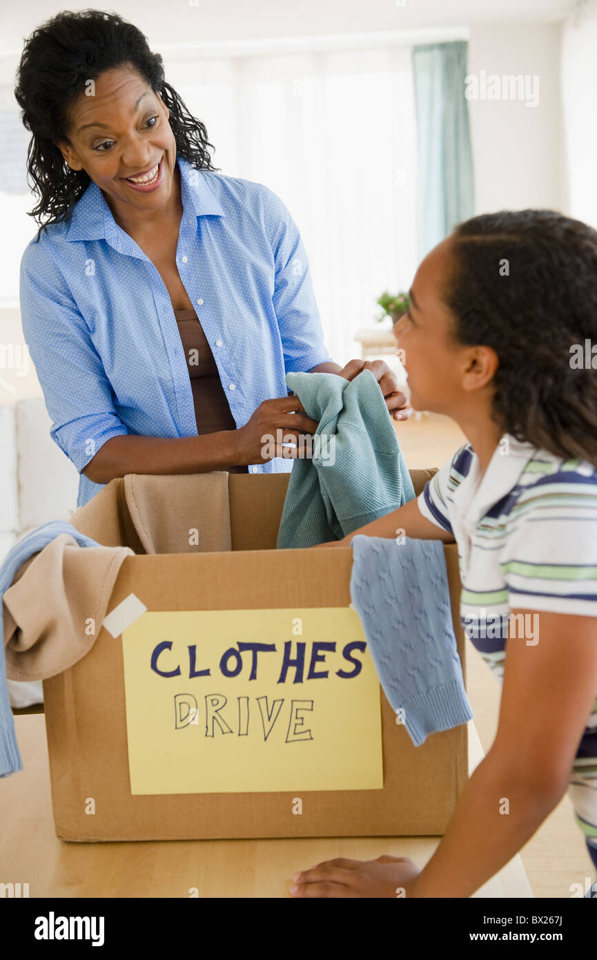 Mother and daughter sorting clothes for clothes drive Stock Photo - Alamy