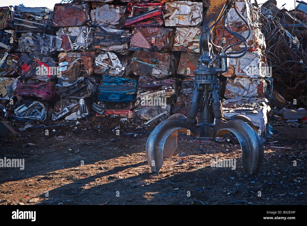 Compressed scrap metal is stacked in cubes in a recycling area ready to ...