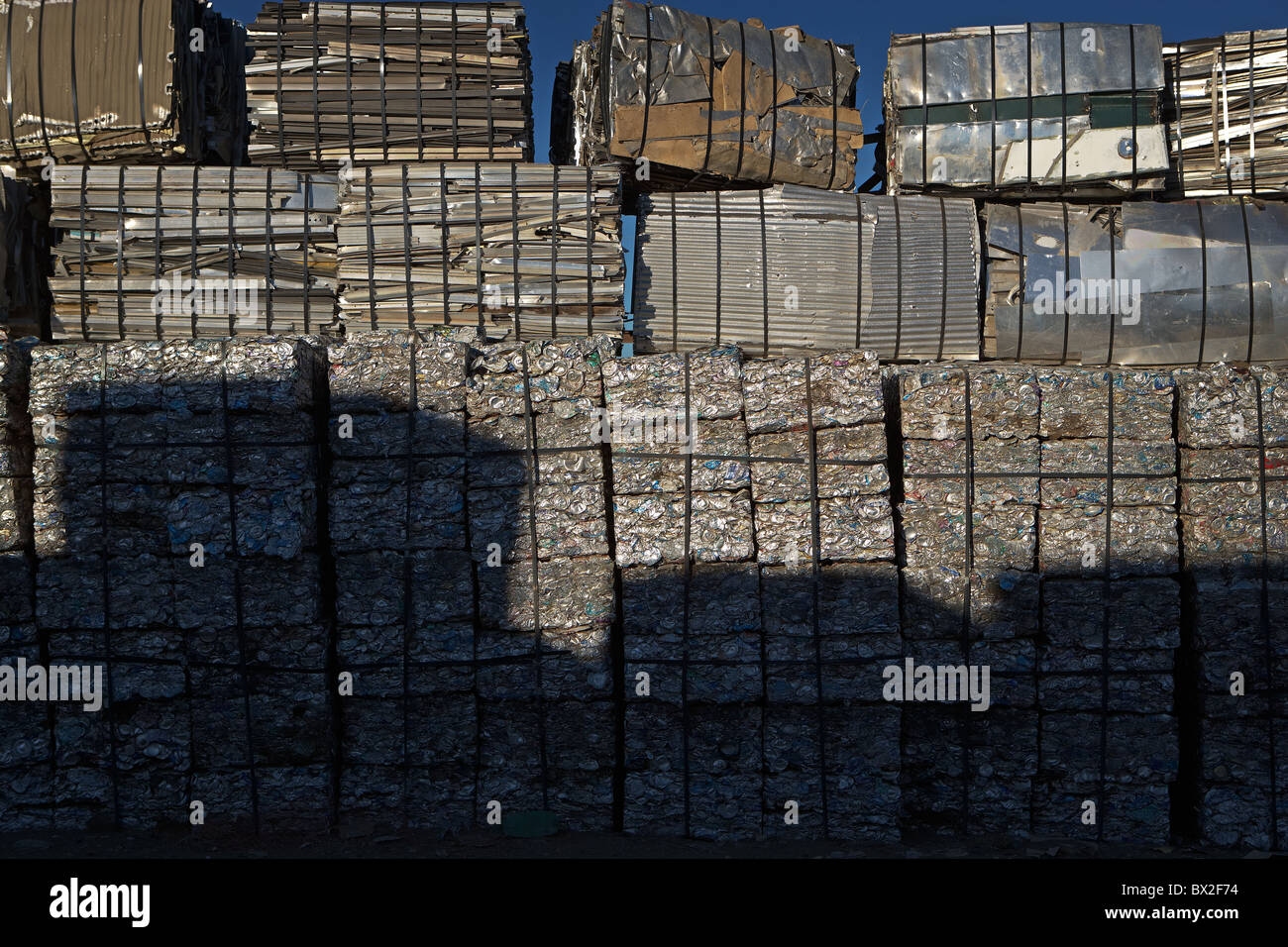 Compressed scrap metal is stacked in cubes in a recycling area ready to ...