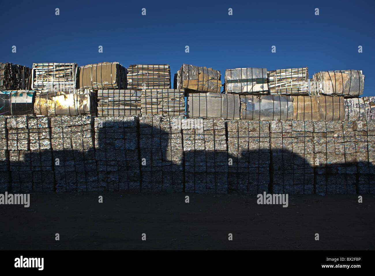 Compressed scrap metal is stacked in cubes in a recycling area ready to ...